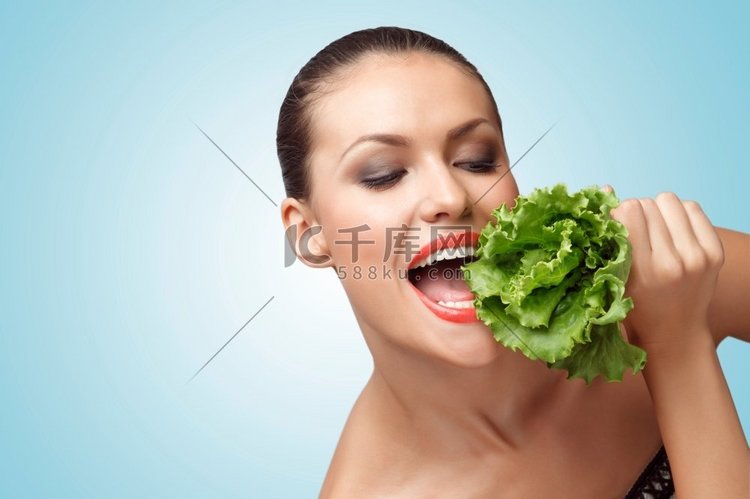 一个美丽饥饿的女孩在吃生菜绿叶的饮食中的创意肖像高清摄影大图 千库网