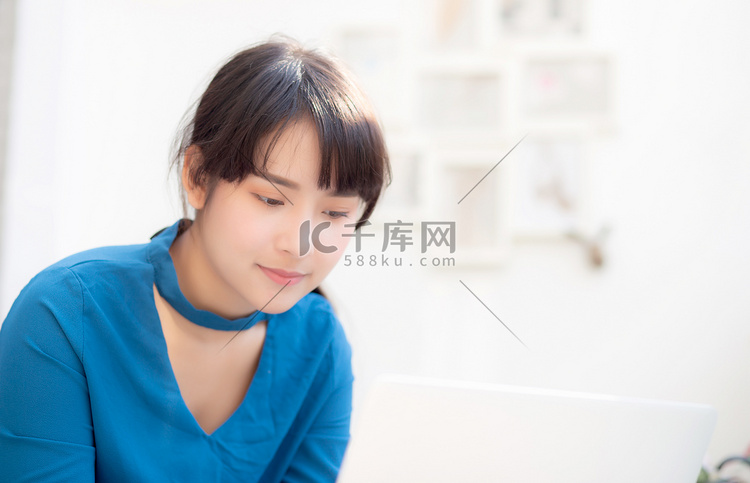 在笔记本电脑上在线工作的美丽肖像亚洲年轻女性坐着高清摄影大图 千库网