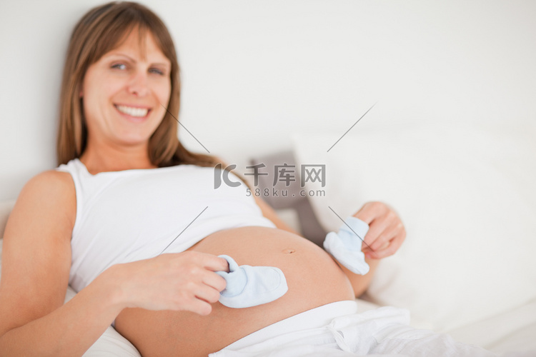迷人的孕妇躺着玩小袜子高清摄影大图 千库网