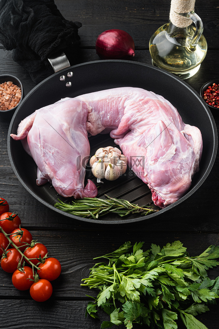生兔肉配新鲜蔬菜香草和香料在铸铁煎锅中黑色木桌背景高清摄影大图 千库网