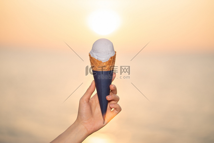 在海滩上用手拿华夫蛋筒舀冰淇淋日落时刻高清摄影大图 千库网