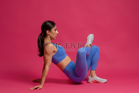 在栗色背景下进行伸展运动的运动型黑发女郎高清摄影大图 千库网