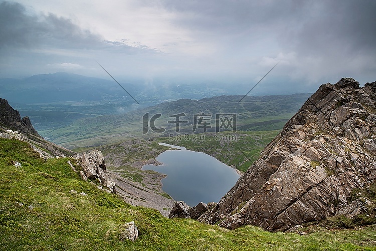 从斯诺多尼亚国家公园的Cadair Idris山顶俯瞰Llyn y Gader，有多云、暴风雨的夏季天空景观高清摄影大图-千库网