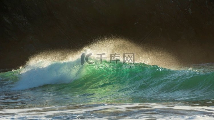 Kynance Cove Cornwall 的翡翠绿松石波浪冲击海岸和岩石的史诗景观图像，日出背景发光，风中喷水滴高清摄影大图-千库网