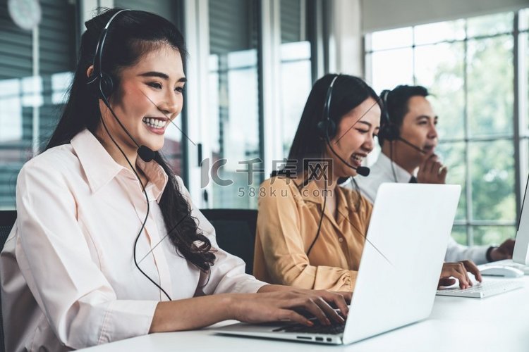 商务人士戴着耳机在办公室积极工作。高清摄影大图-千库网