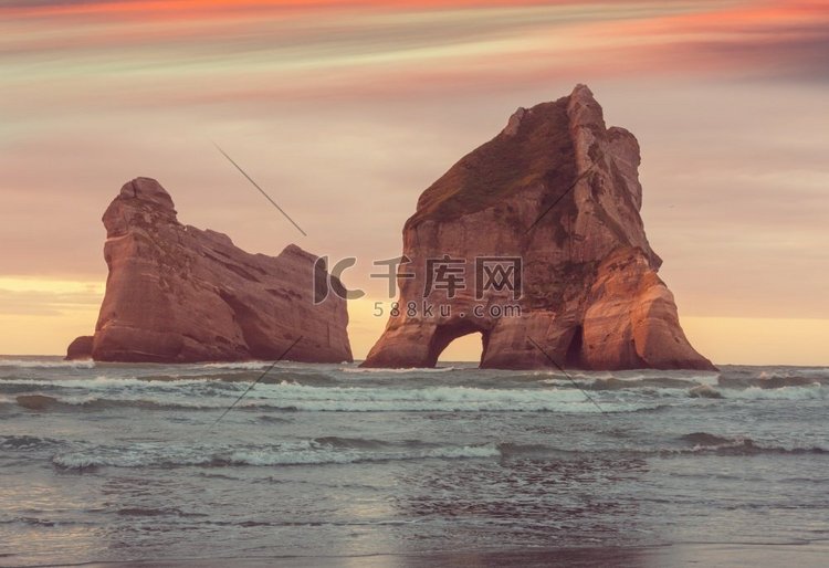 新西兰日落时分的瓦拉里基海滩拱门群岛自然/人文景观戈壁高清摄影大图-千库网