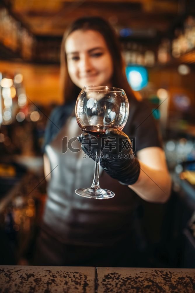 围裙的女调酒师在吧台递出一杯酒。高清摄影大图-千库网