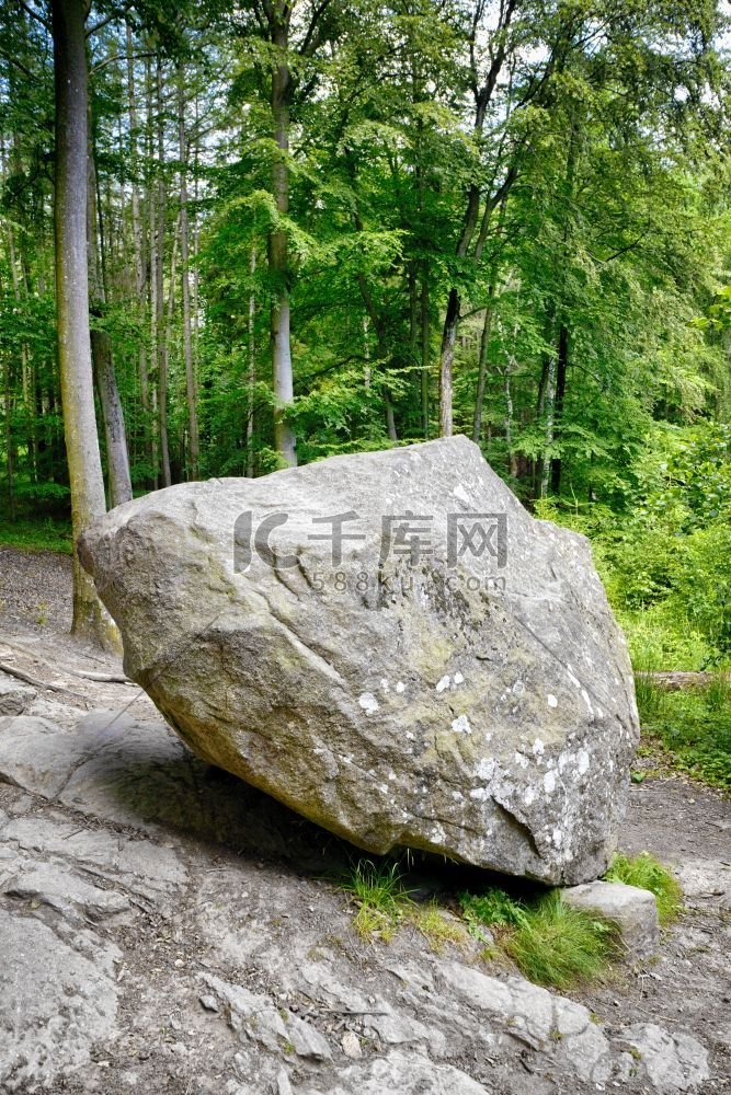 夏天绿色森林中的大石头，大石头下有坚实的地面雕像历史遗迹高清摄影大图-千库网