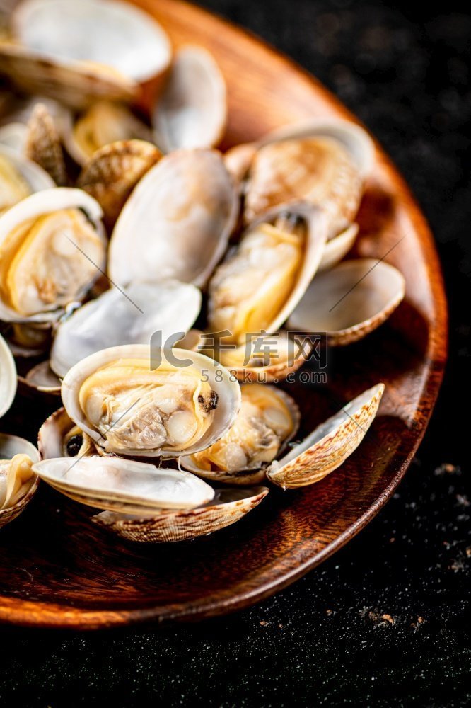 一个装满新鲜的 vongole 的木盘。蘑菇食物高清摄影大图-千库网