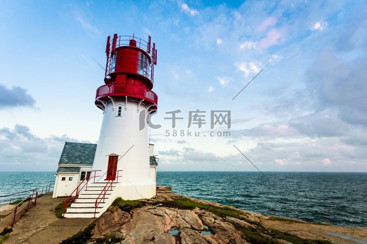 位于岩石海岸边缘的历史悠久的红白色灯塔，南挪威，Lindesnes Fyr 灯塔。高清摄影大图-千库网