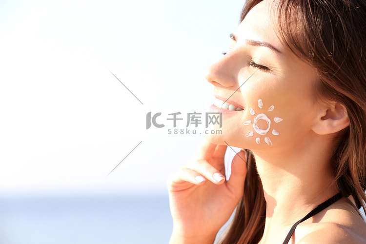 Young woman with sunscreen on face, sea background高清摄影大图-千库网