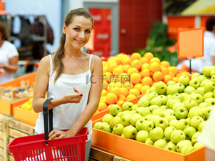 Young woman shopping in a supermarket in the department of fruit高清摄影大图-千库网