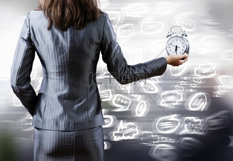 时间在流逝。女商人拿着旧闹钟的背影高清摄影大图-千库网