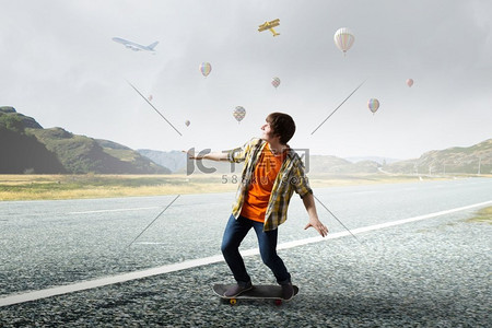 男孩骑滑板。在柏油路上骑滑板的好手高清摄影大图-千库网