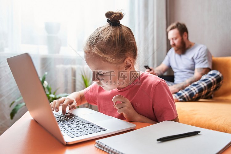 Child is sitting at desk and doing homework高清摄影大图-千库网