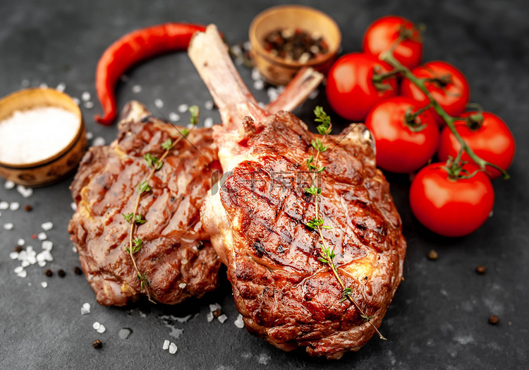 grilled beef steaks - tomahawk with tomatoes and red pepper on a stone ...