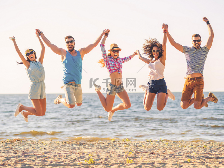 happy young people jumping on beach高清摄影大图-千库网