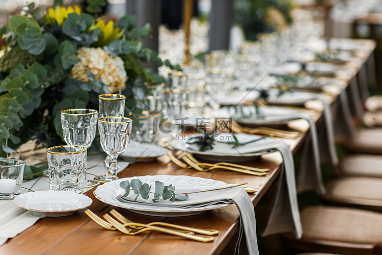 Decorated plate with fork and spoon. Table set up in boho style with ...