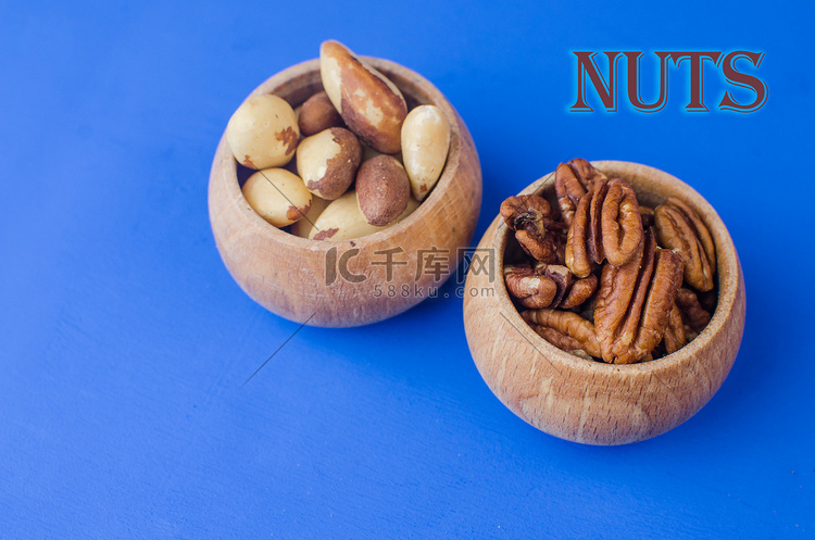 蓝色背景的Pekan和brazil坚果。健康食品高清摄影大图-千库网