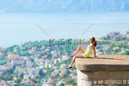 漂亮的女孩坐在城市上空高清摄影大图-千库网