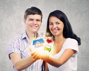 年轻的家庭。幸福的年轻夫妇手持掌上房屋的典范高清摄影大图-千库网