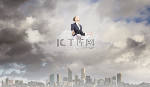 放松的女商人。年轻漂亮的女士坐在云端练习瑜伽高清摄影大图-千库网