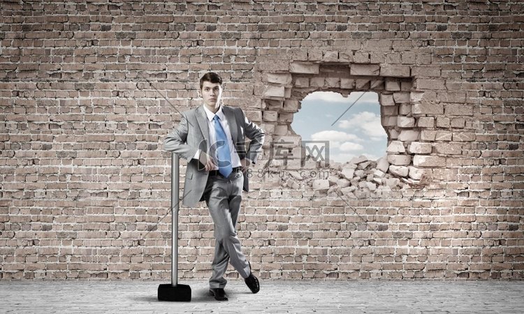 克服挑战。手里拿着大锤子的坚定商人高清摄影大图-千库网