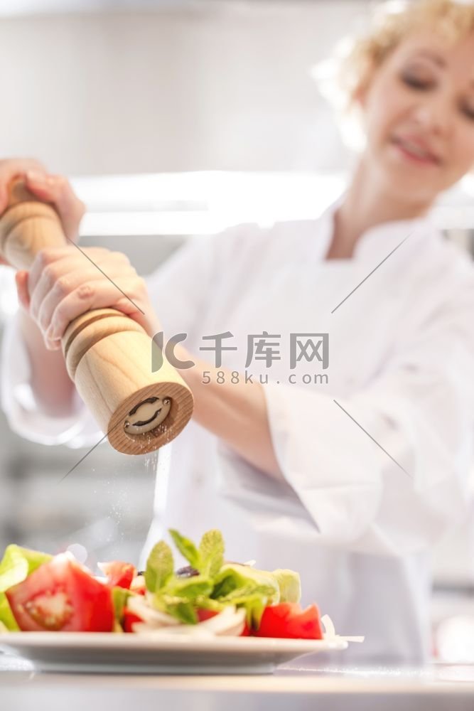 成熟的厨师使用胡椒磨沙拉在盘子在餐厅高清摄影大图-千库网