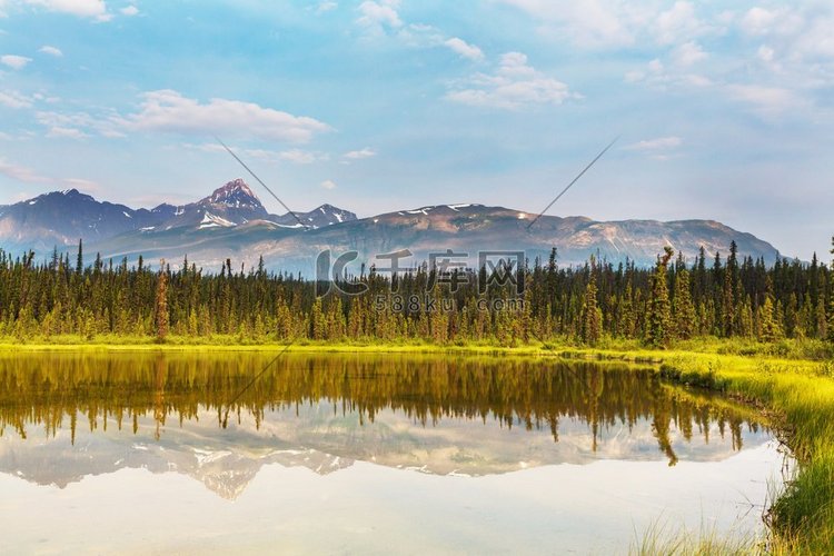 加拿大的湖。加拿大山湖边宁静的景色，平静的水中倒映着岩石。高清摄影大图-千库网