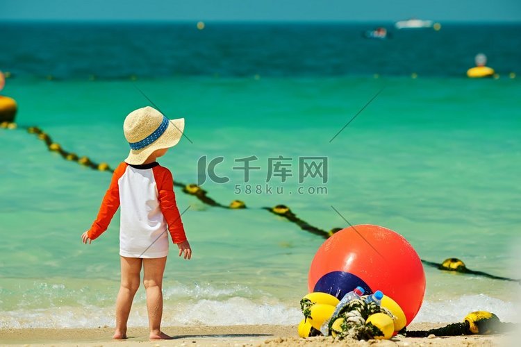 两岁蹒跚学步的男孩走在海滩上。婚纱写真海洋高清摄影大图 千库网