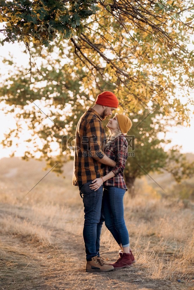 愉快的家伙和女孩在一个明亮的针织帽子和格子衬衫散步高清摄影大图-千库网