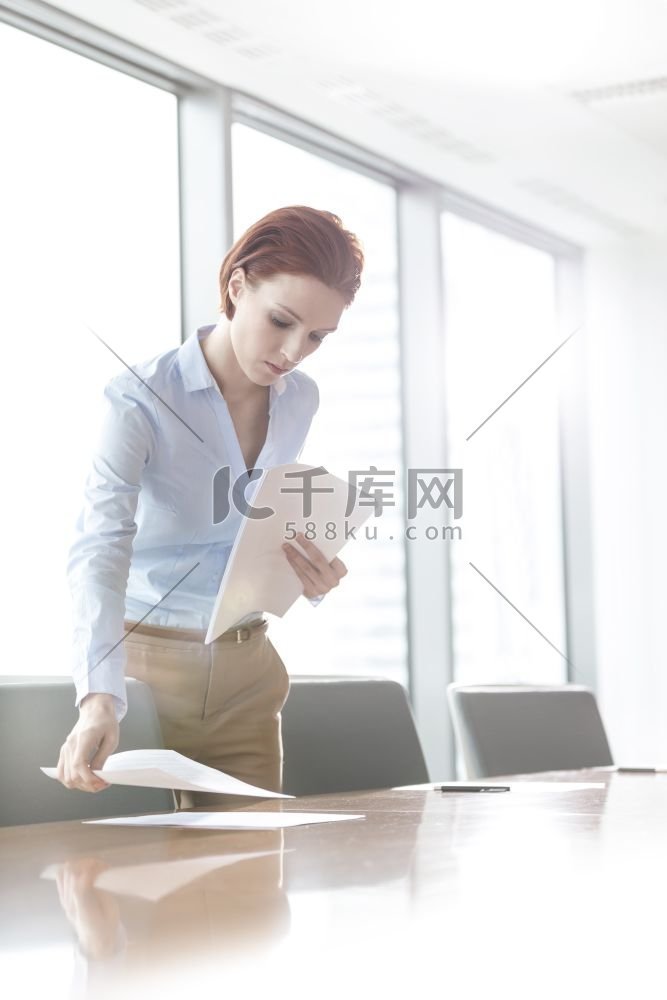 年轻的女商人安排在会议桌上的文件在明亮的会议室在办公室高清摄影大图-千库网