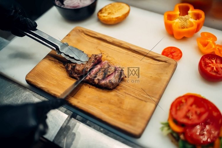 厨师手戴手套切多汁的牛排片。新鲜牛排烹饪，厨房准备食物高清摄影大图-千库网