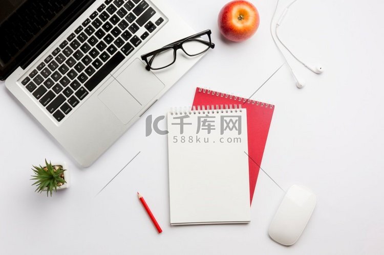眼镜笔记本电脑苹果耳机彩色铅笔螺旋记事本鼠标白色办公桌高清摄影大图-千库网