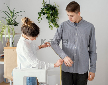 侧面视图女裁缝测量男性客户衬衫2高清摄影大图-千库网