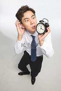 商务青年男人拿着闹钟高清摄影大图-千库网