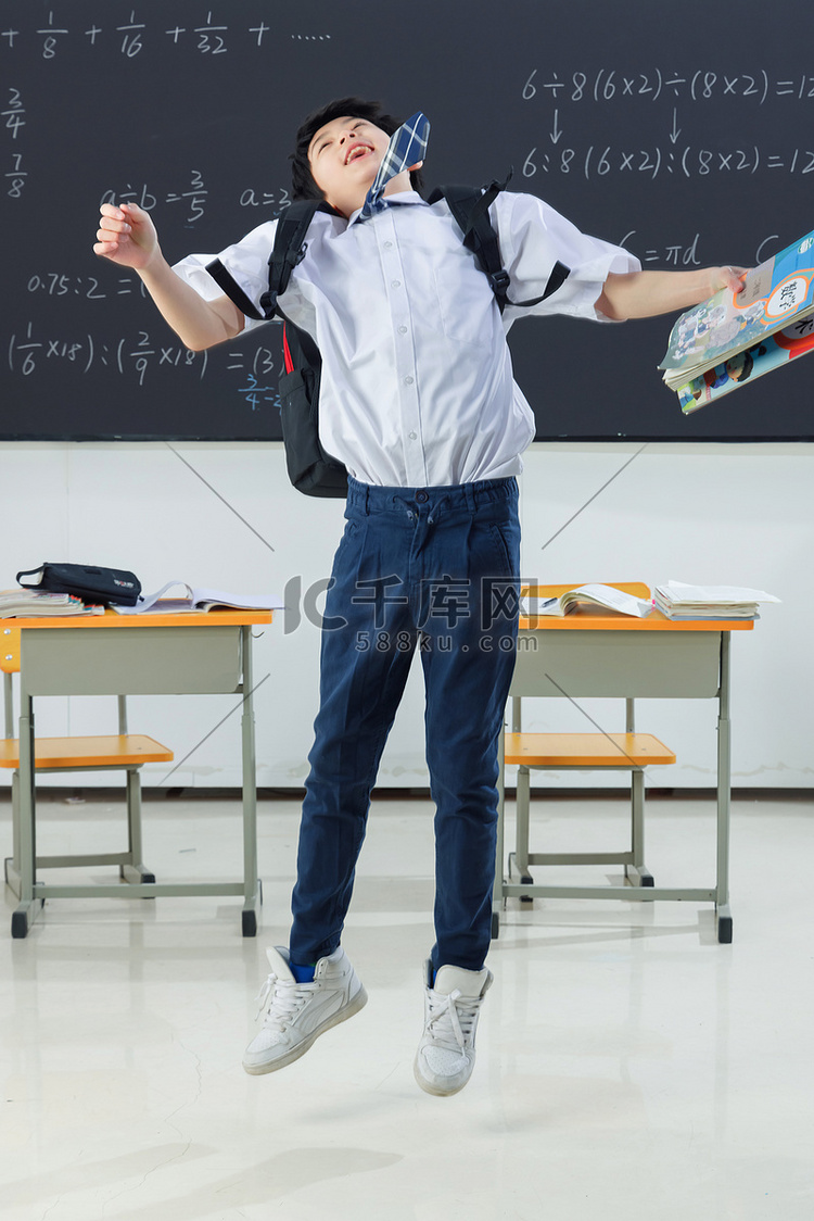 快乐的小学男生在教室里欢呼跳跃高清摄影大图-千库网