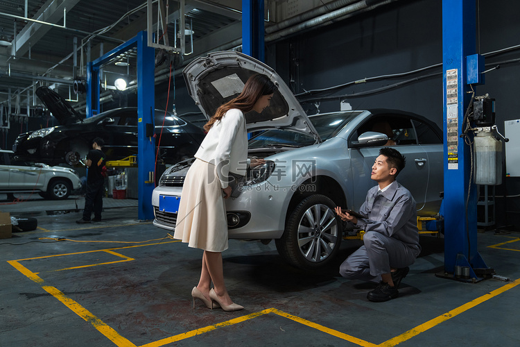 汽车维修保养人员和顾客沟通高清摄影大图-千库网