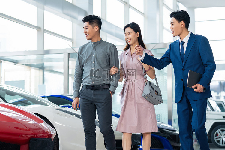 汽车销售人员为青年夫妇介绍高清摄影大图-千库网