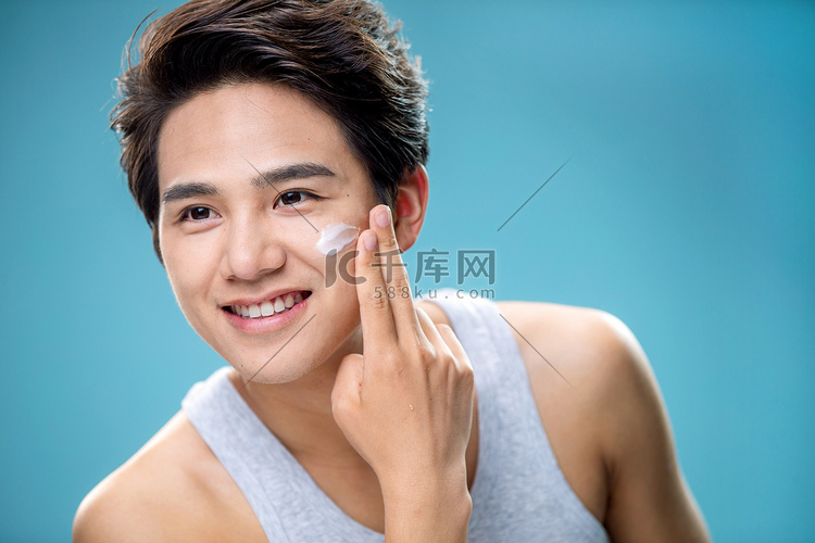 涂抹润肤乳的年轻男人高清摄影大图 千库网