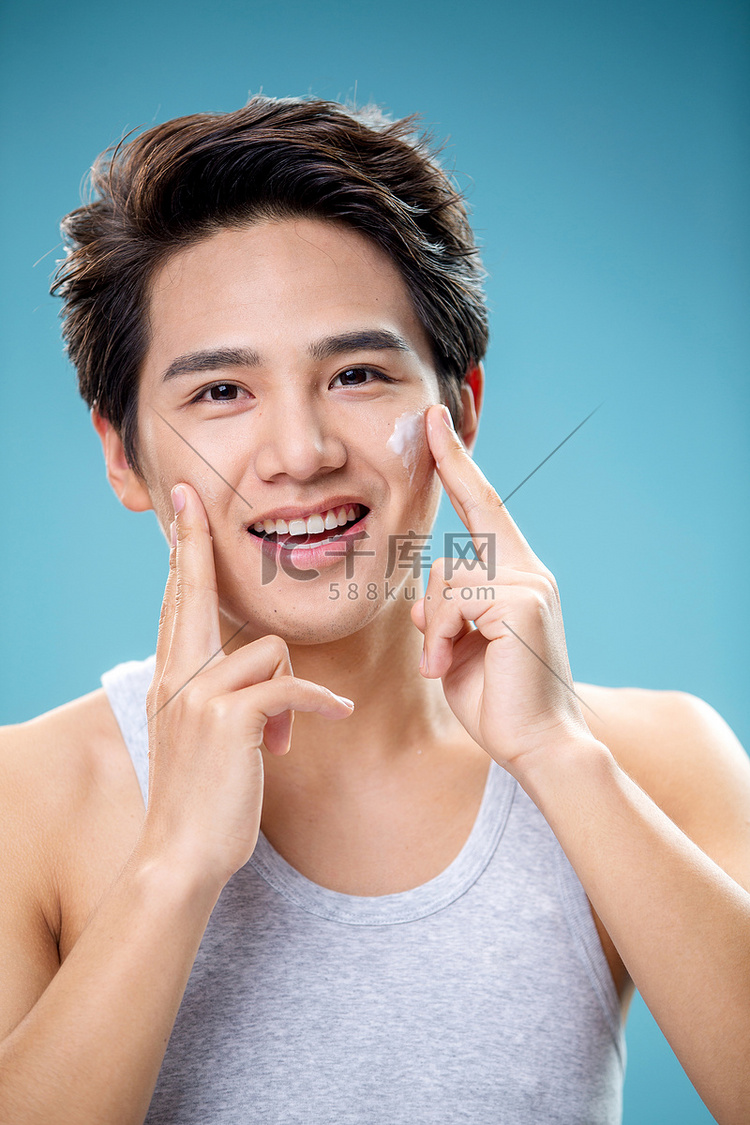 涂抹润肤乳的年轻男人高清摄影大图 千库网
