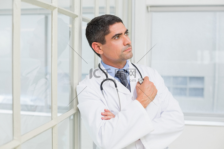 体贴的男医生在医院里望向别处高清摄影大图-千库网