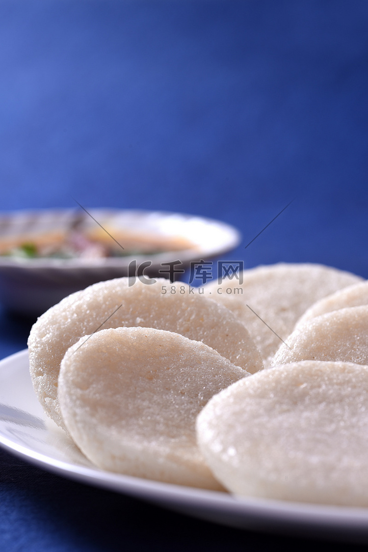 Idli 与 Sambar 和椰子酸辣酱在蓝色背景，印度菜：南印度最喜欢的食物 rava idli 或 semolina idly 或 ...
