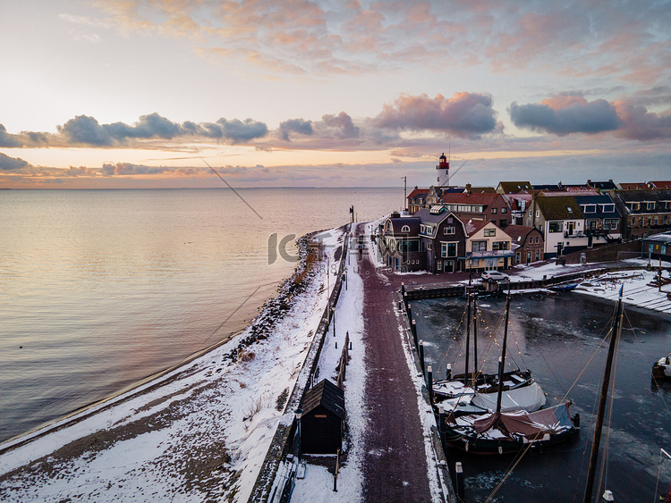 Urk 荷兰灯塔在冬季与白雪覆盖的海岸线，Urk 视图在灯塔雪景冬季天气在荷兰高清摄影大图-千库网