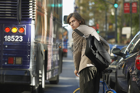 在繁忙的街道上站在自行车旁的男人高清摄影大图-千库网