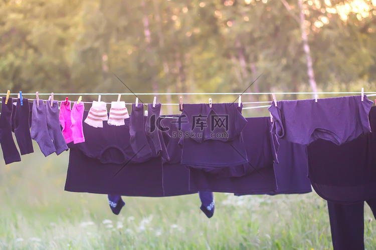 乡村庭院晾衣绳上挂着五颜六色的衣服和衣物高清摄影大图-千库网