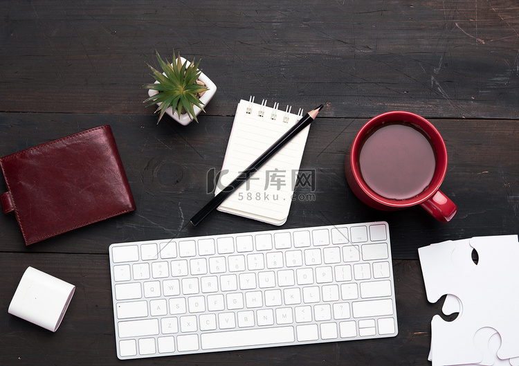 白色无线键盘和无线耳机，以及棕色木桌上的棕色皮夹高清摄影大图-千库网