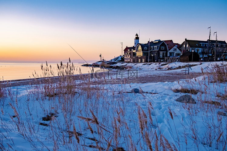 Urk 荷兰灯塔在冬季与白雪覆盖的海岸线，Urk 视图在灯塔雪景冬季天气在荷兰高清摄影大图-千库网