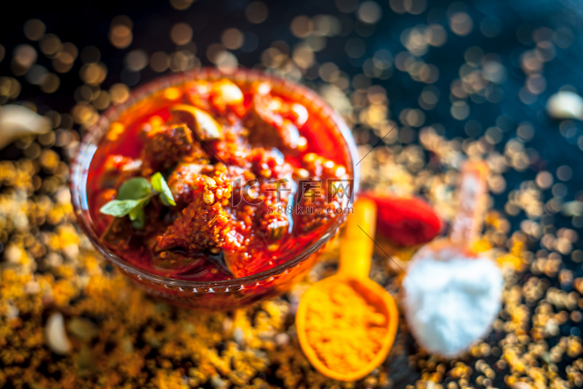 玻璃碗中流行的印度和亚洲芒果泡菜，即玻璃碗中的 Aam ka achar 或 keri ka achar，其全部原料包括香料和黑色闪亮表面的 ...