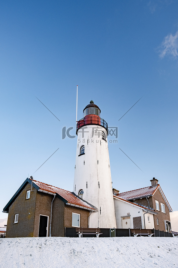 Urk 的冬天，Urk 灯塔旁的堤坝和海滩在冬天被雪覆盖，Urk Flevoland 灯塔旁的日落高清摄影大图-千库网